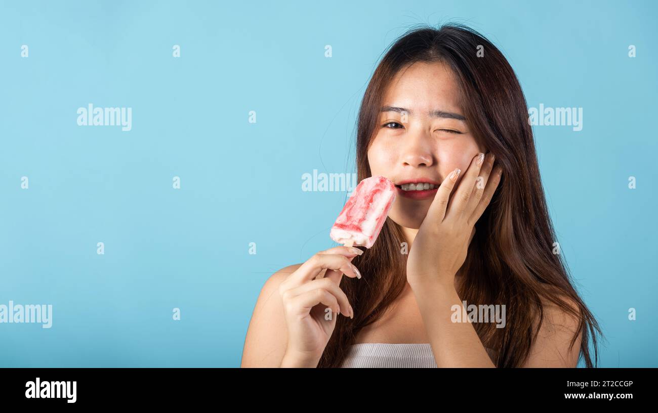 Portrait of Asian young woman with sensitive teeth after eating ...