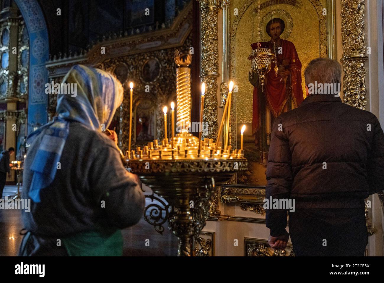 Kyiv, Ukraine. 18th Oct, 2023. A civilian is seen praying while a lady ...