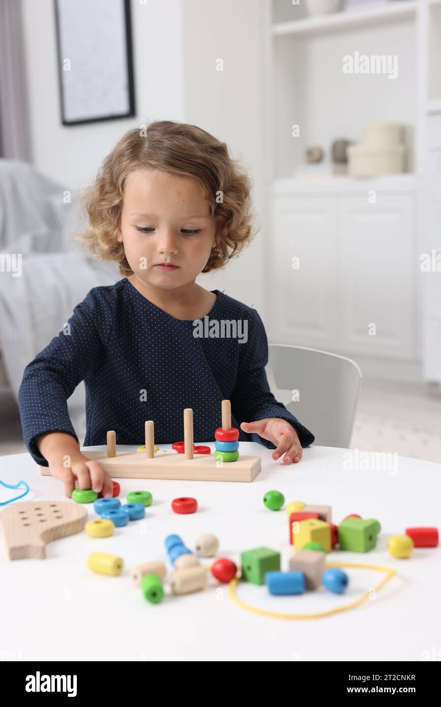 Motor skills development. Little girl playing with stacking and ...
