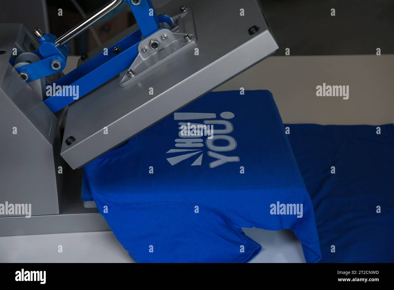 Printing logo. Heat press with blue t-shirt on white table Stock Photo ...