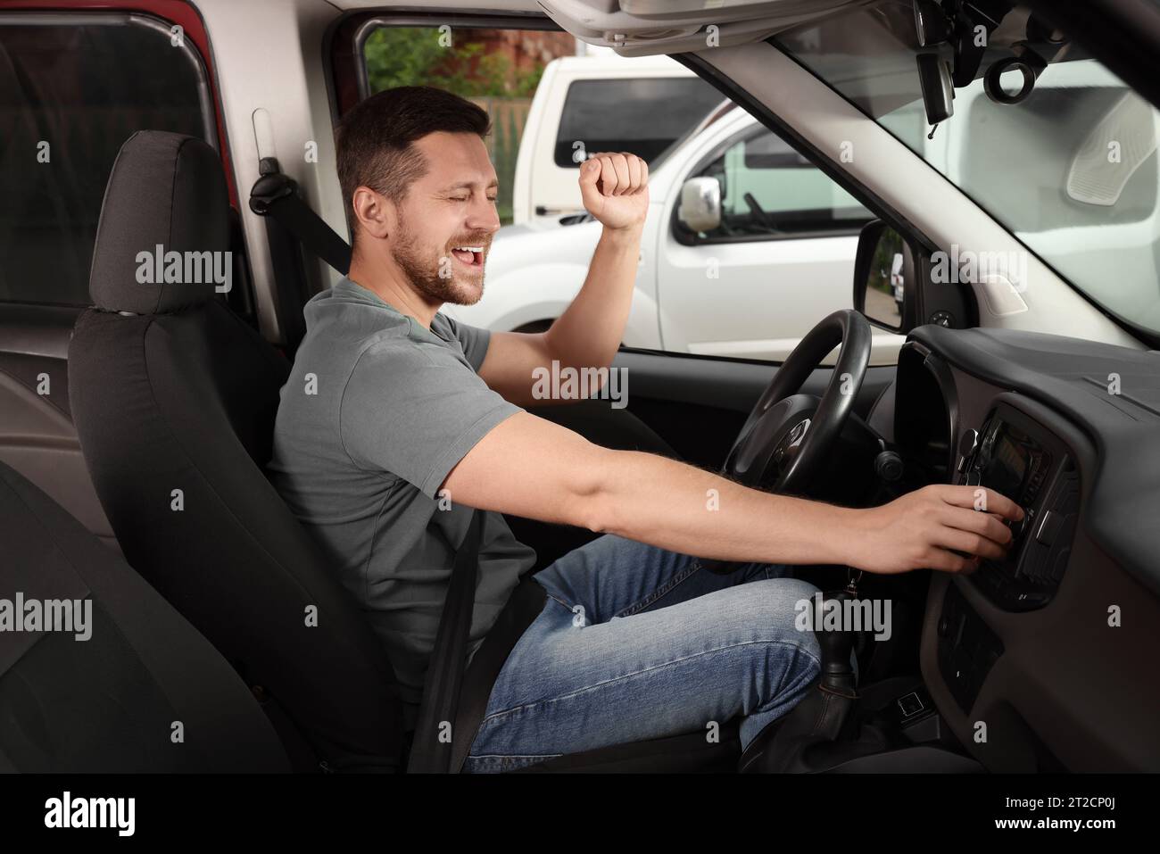Choosing favorite radio. Handsome man pressing button on vehicle audio ...