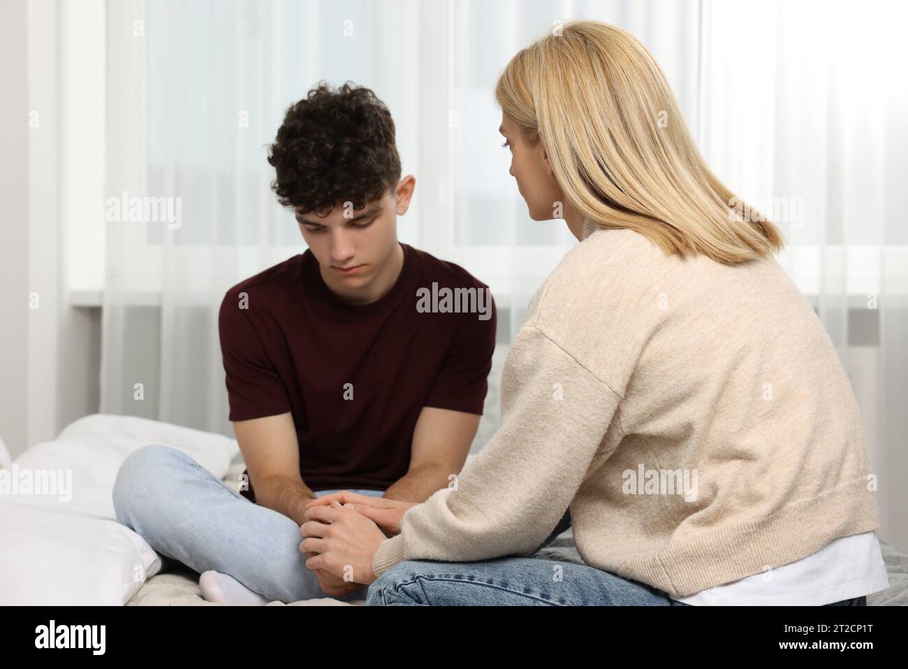 Mother consoling her upset son in bedroom. Teenager problems Stock ...