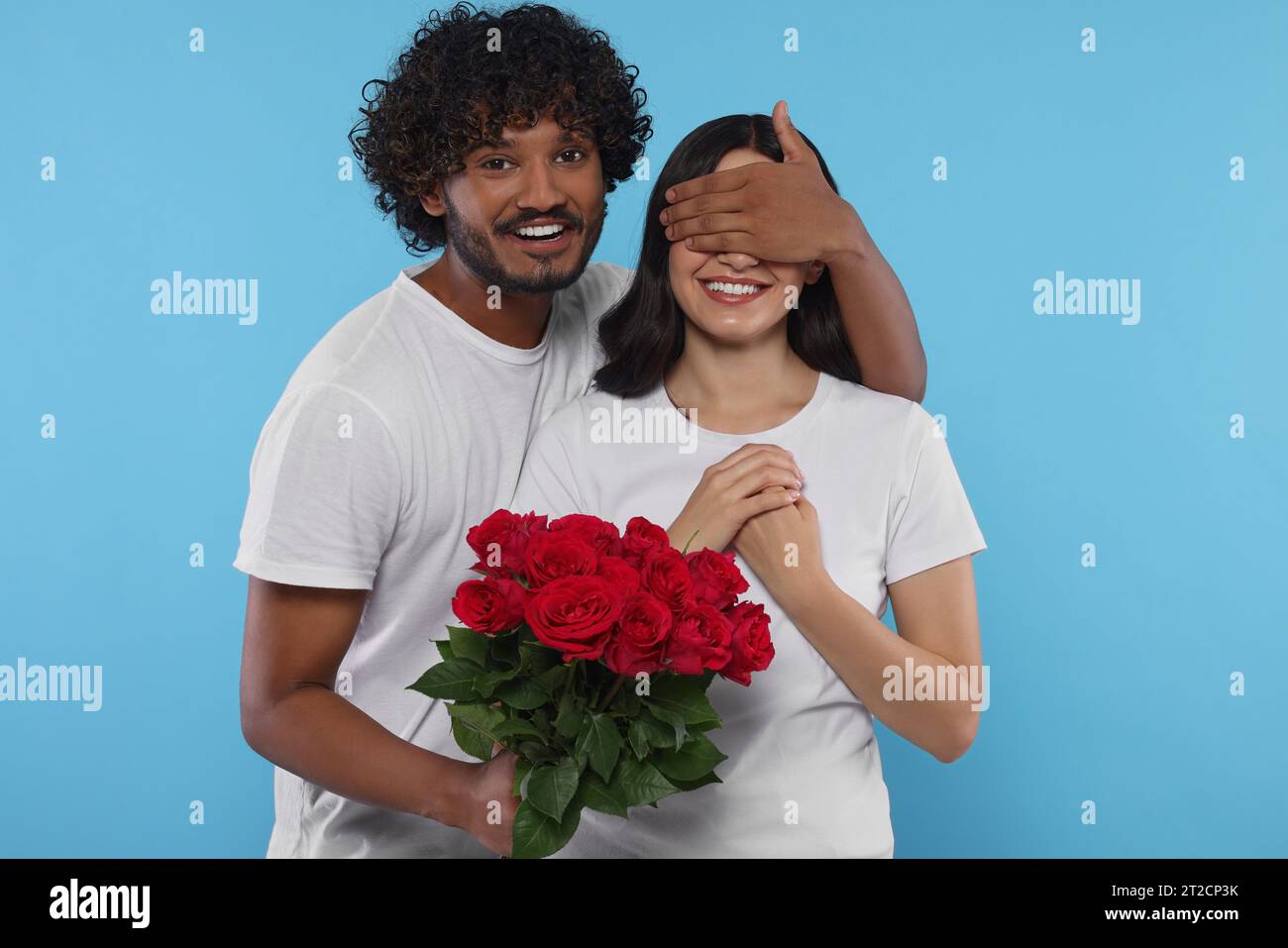 International dating. Handsome man presenting roses to his beloved ...