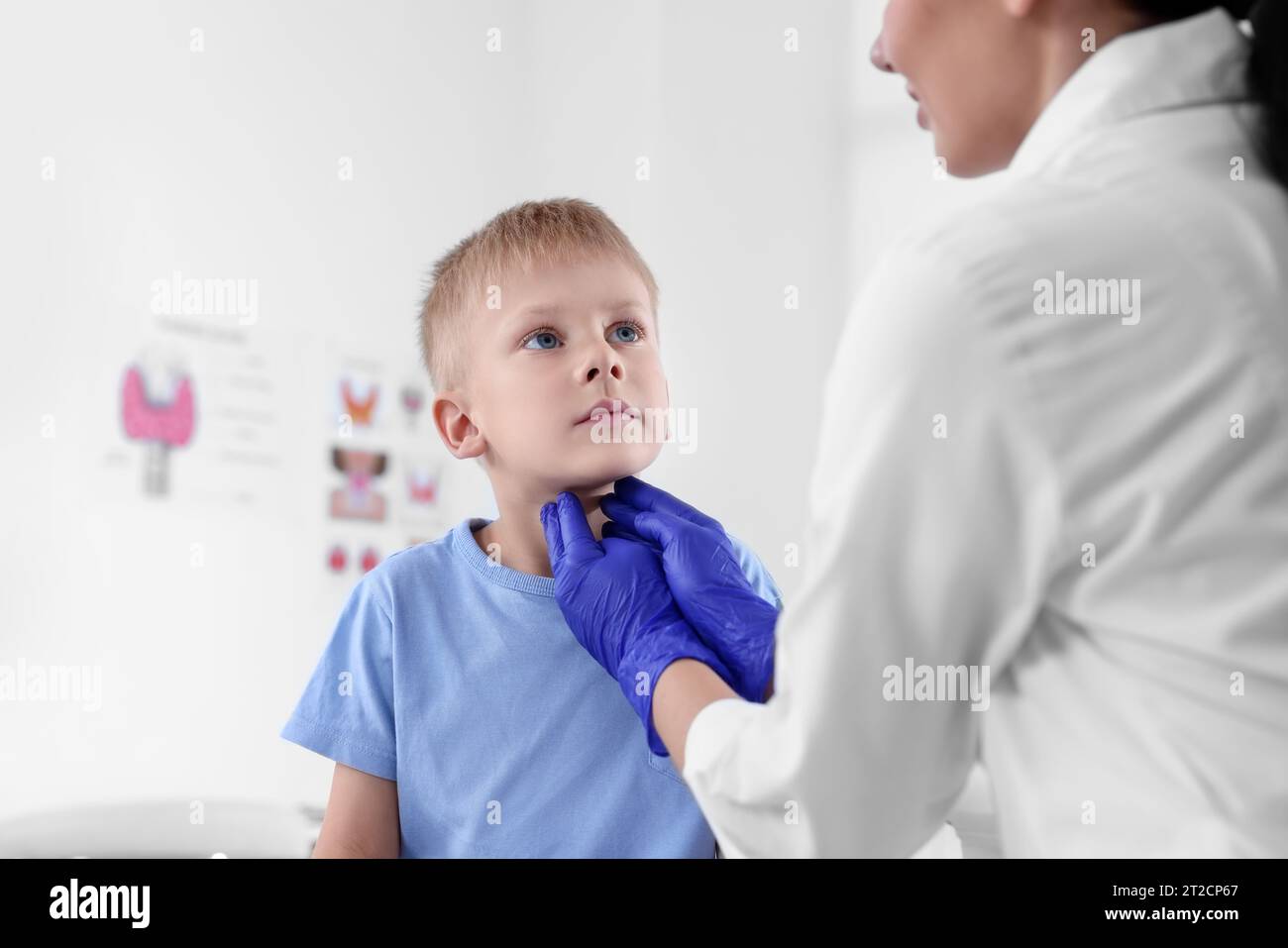 Endocrinologist examining boy's thyroid gland at hospital, closeup ...