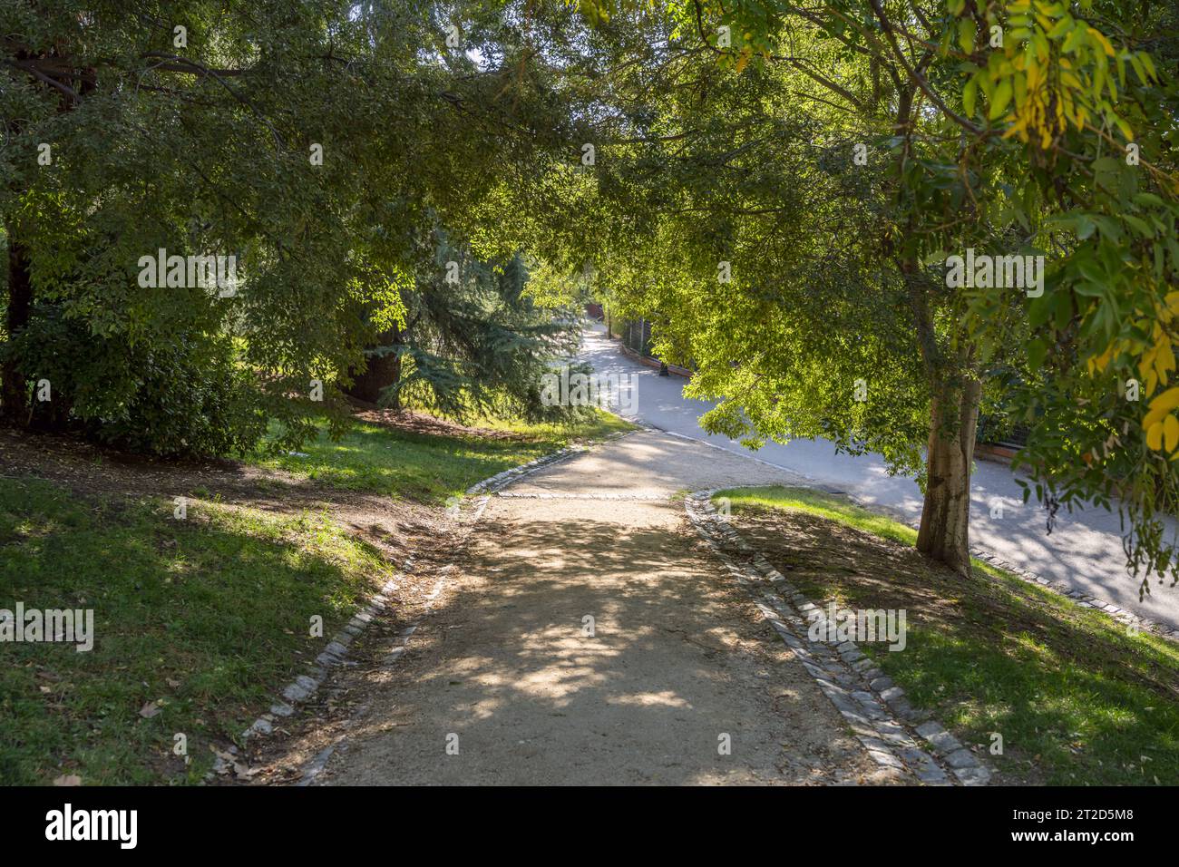 Dirt paths between gardens, trees and grass Stock Photo - Alamy