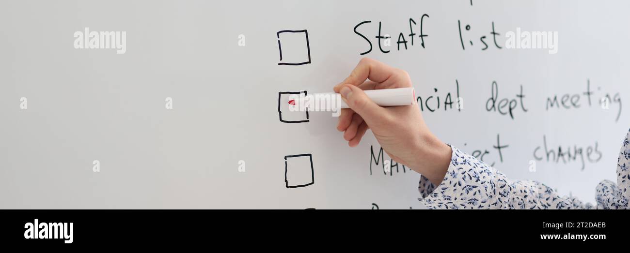 Female worker marks schedule points written on whiteboard Stock Photo ...