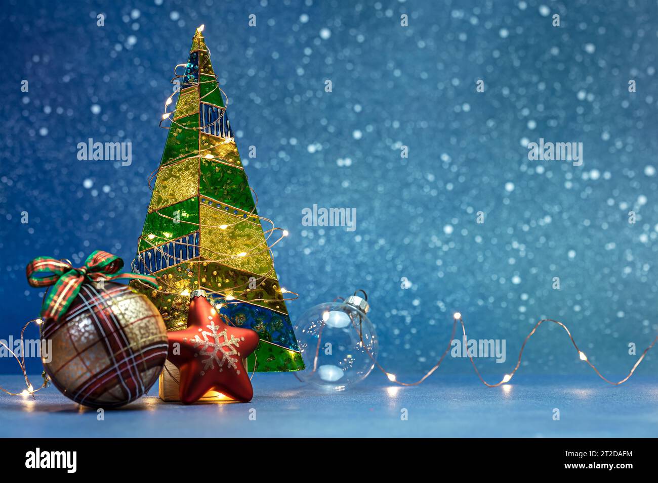 christmas decorations on blue background - fir tree with burning lights ...