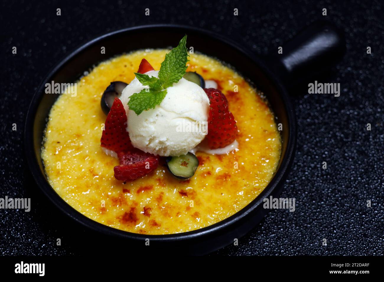 crema catalana or creme brulee with ice cream and fresh berries with ...