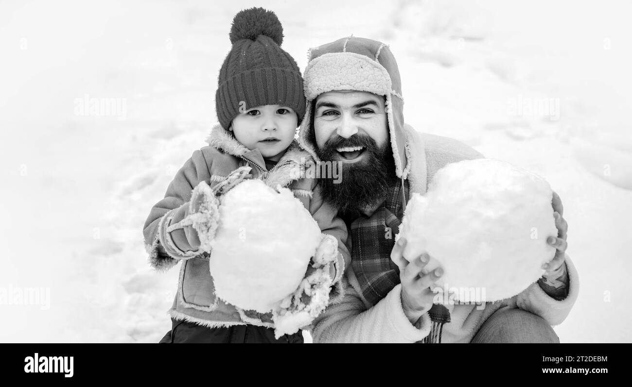 Excited father and son making snowball in the snow. Dad and child ...