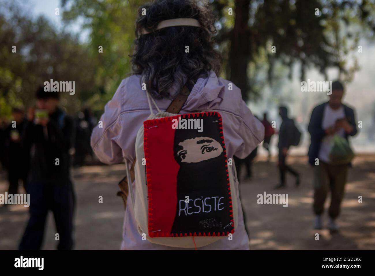 A woman carries on her back a banner with the word -Resist-. During the ...