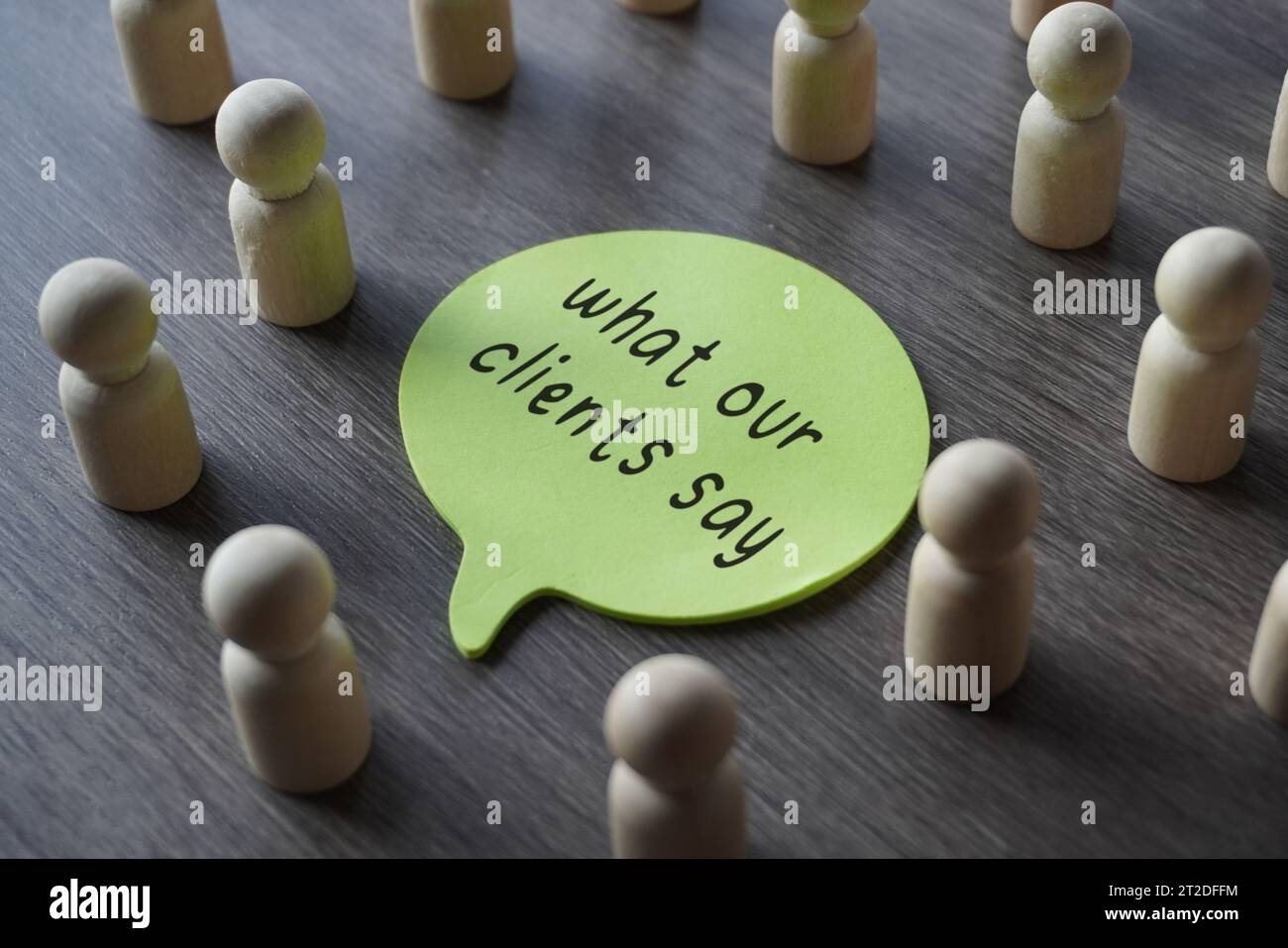 A group of wooden figurines surrounding a speech bubble with text WHAT ...