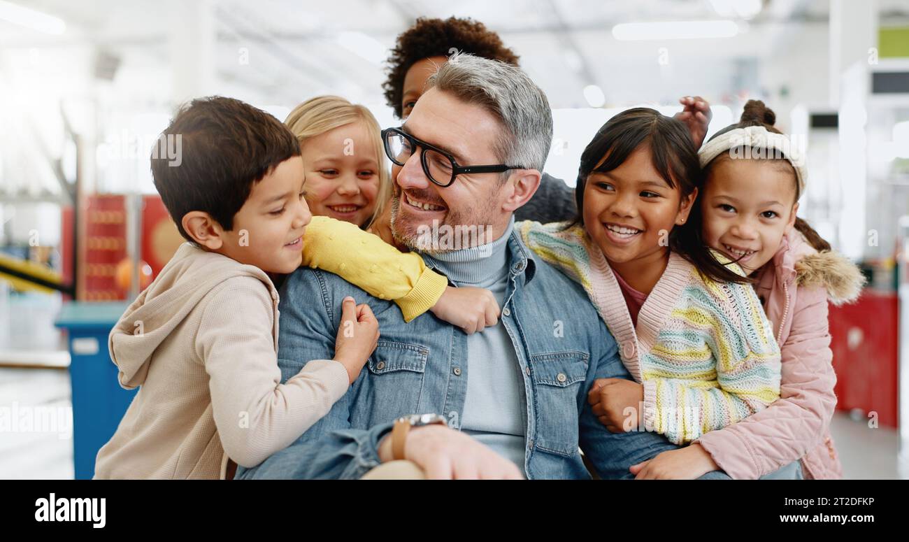 Hug, children and male teacher with happiness, smiling and excited for ...