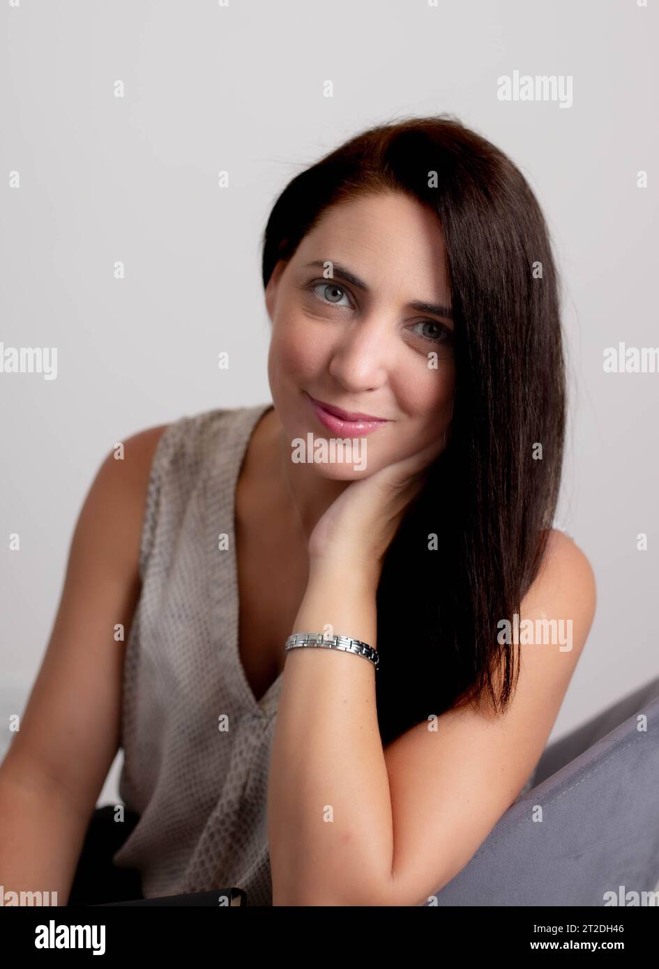 A young female adult looking thoughtfully at the camera while resting ...