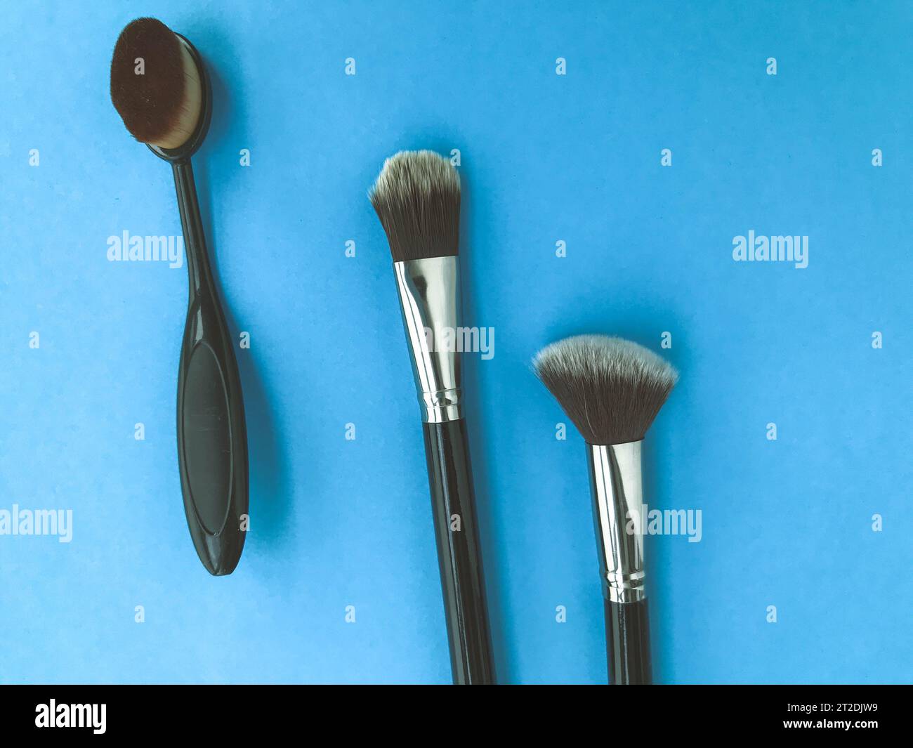 brushes on a blue background. three brushes for tone, contouring ...