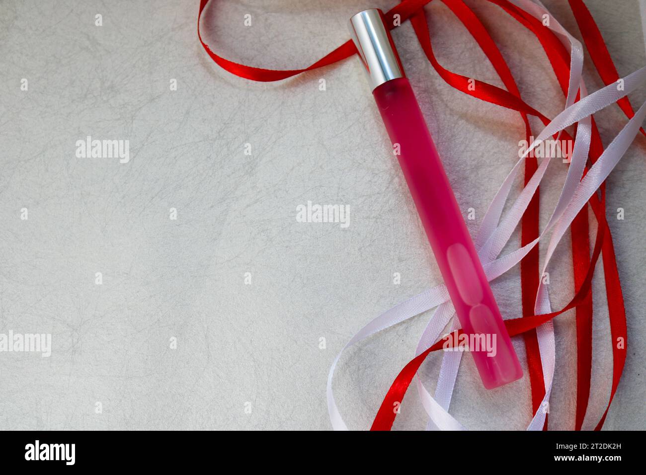 Texture with a pink matte thin long cylindrical perfume bottle, cologne ...