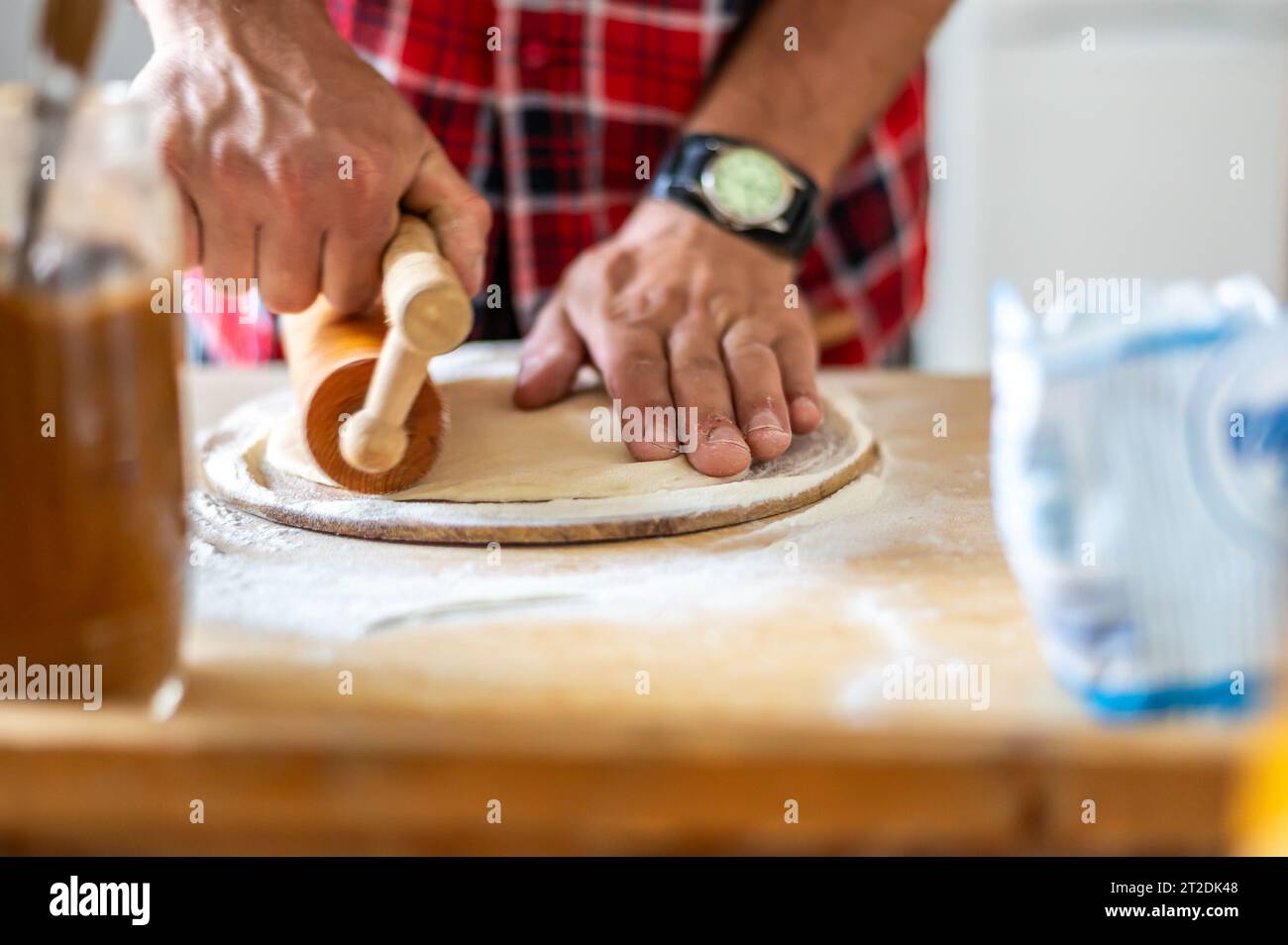 Detail of hands of men rolling the dough. Preparation for baking of ...
