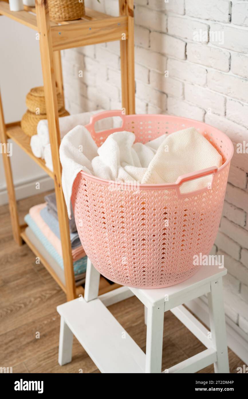 Pink plastic laundry basket in a bathroom Stock Photo - Alamy