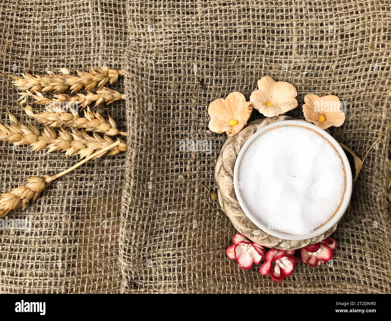Wheat spikelets of straw and salt shaker with salt on an old brown ...
