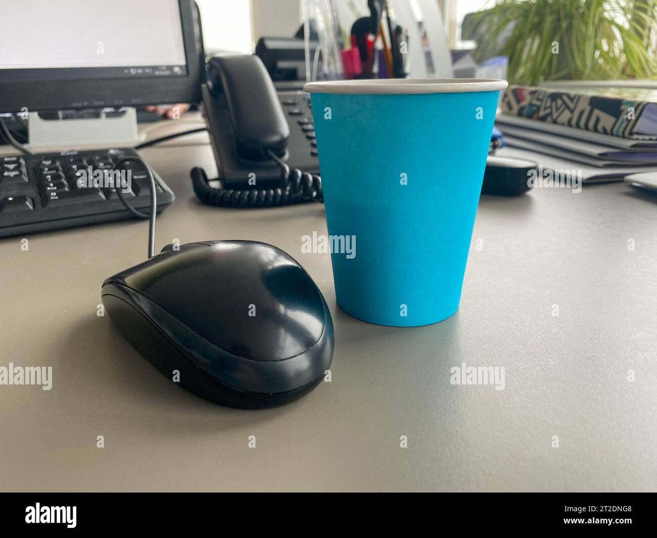 Cardboard blue coffee cup from a coffee shop on a desktop with a ...