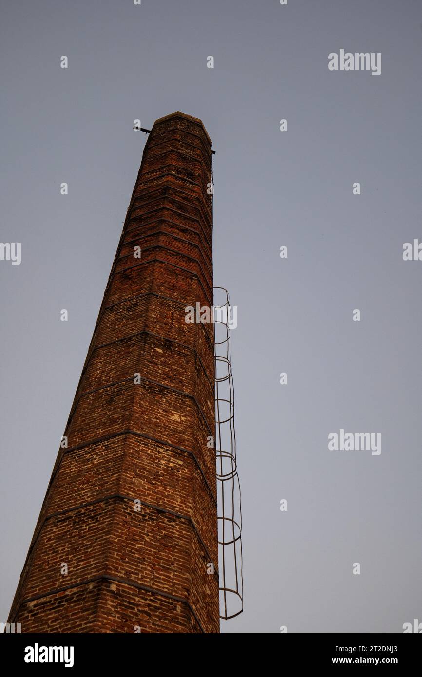 Old, run down, decaying, tall brick chimney of an abandoned urban power ...