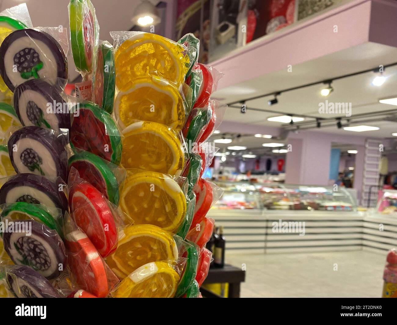 Many colorful lollipops on a stick. Sweets are sold at the city fair ...