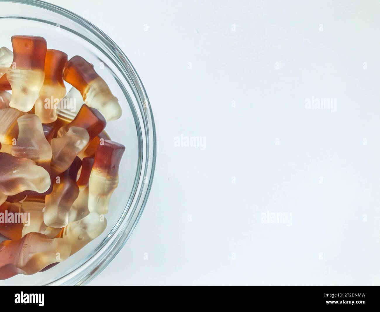 the bottle-shaped marmalade is in a small, round and transparent plate ...