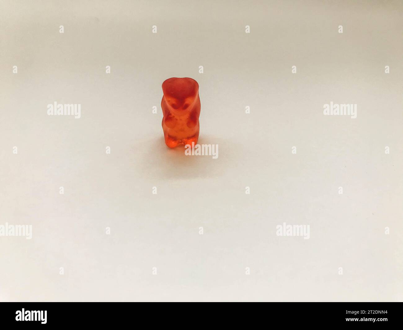 orange gummy bear stands on a white matte background. lonely edible ...