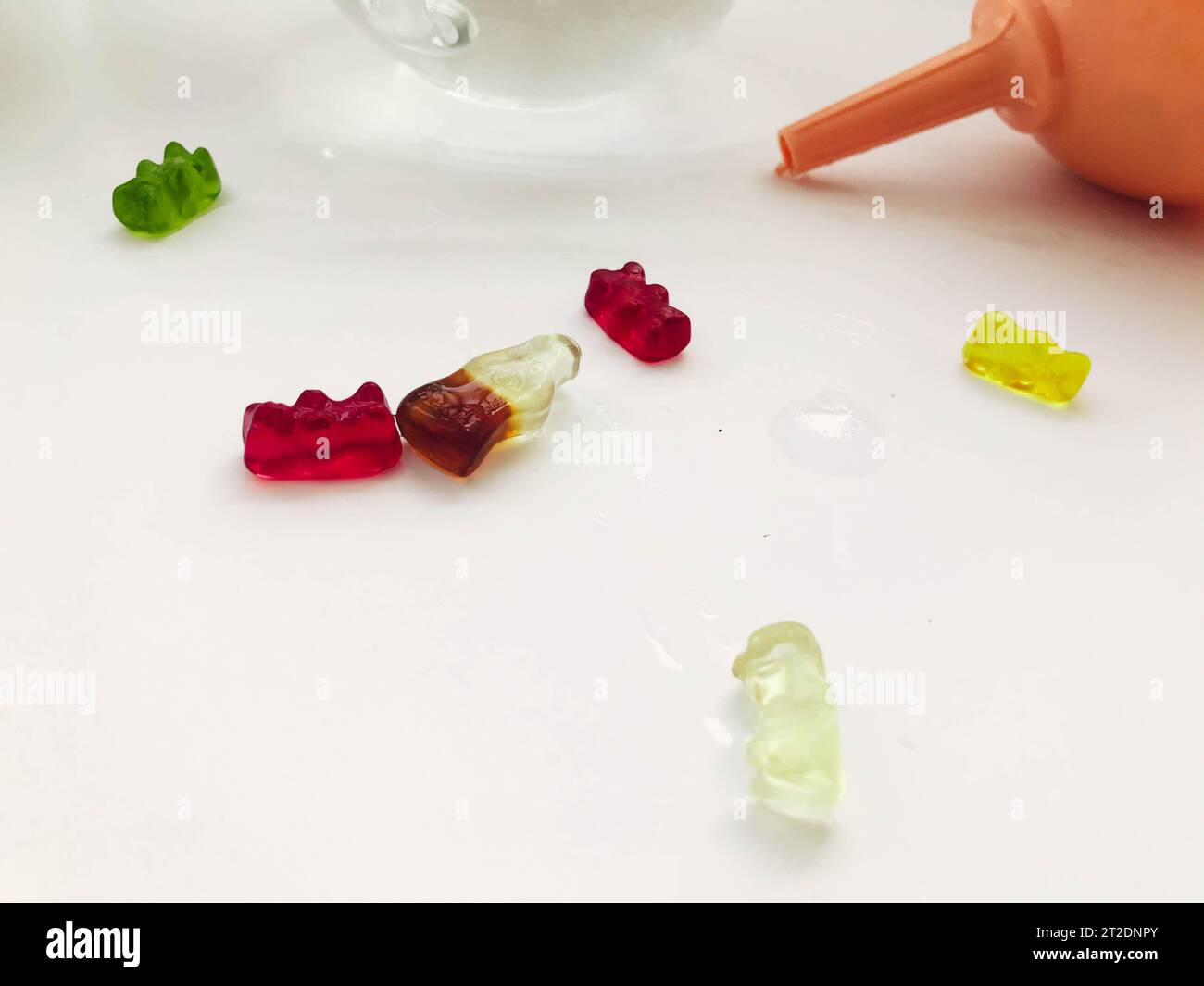 gummy gelatinous bears lie on a wet white matte background. sweet ...