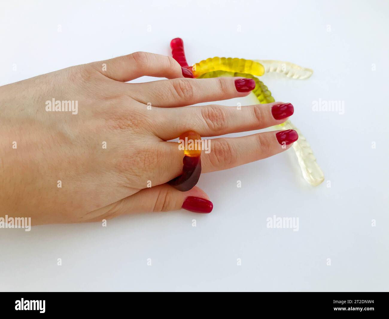 long, mouth-watering, multi-colored worms lie on the girl's hand with a ...