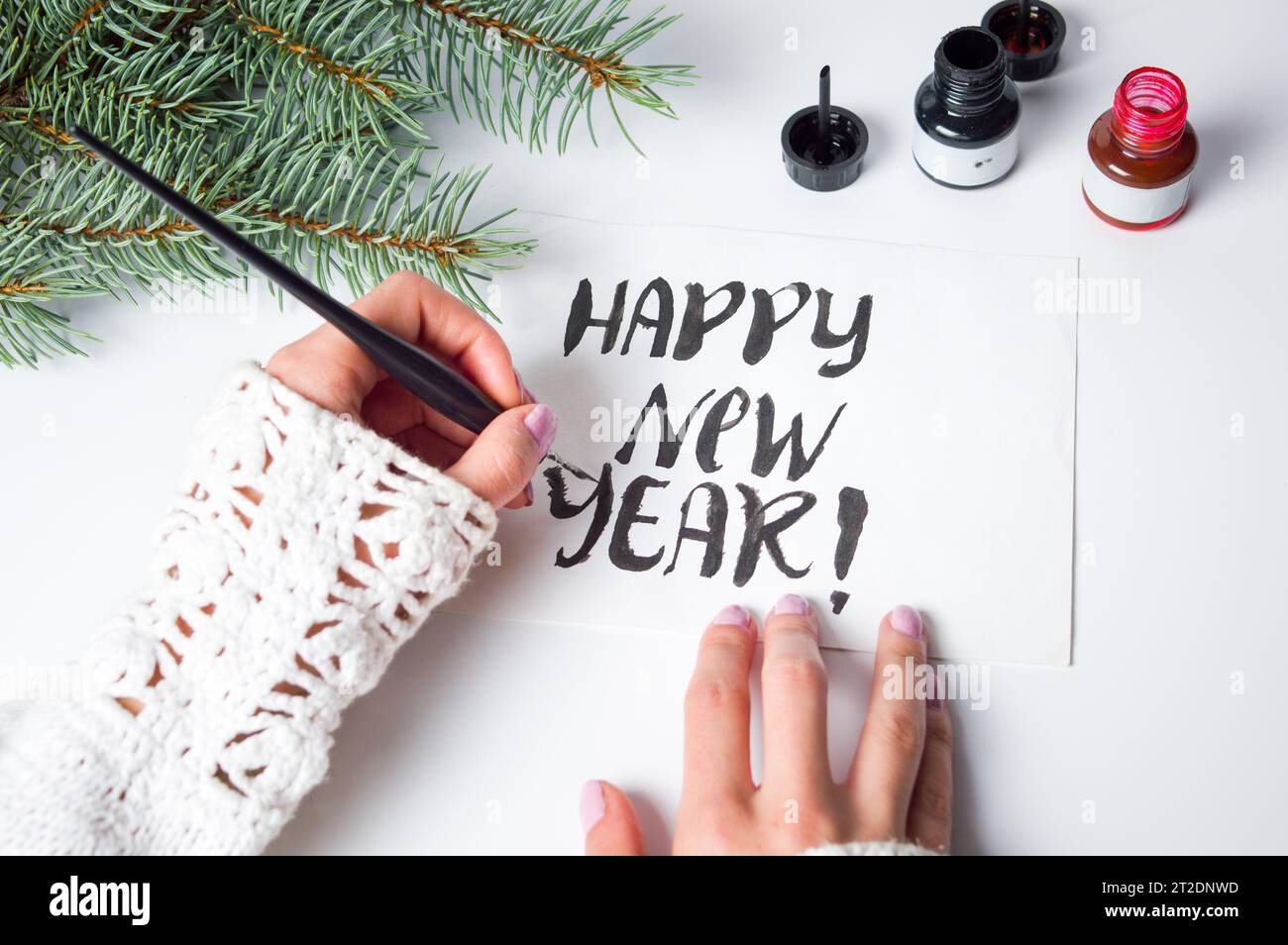 Girl writing Happy new year calligraphy card top view Stock Photo - Alamy