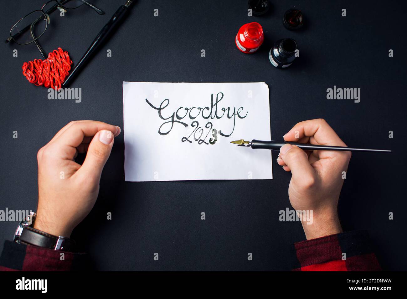 Man writing Goodbye 2023 New Year note with a calligraphy fountain pen ...