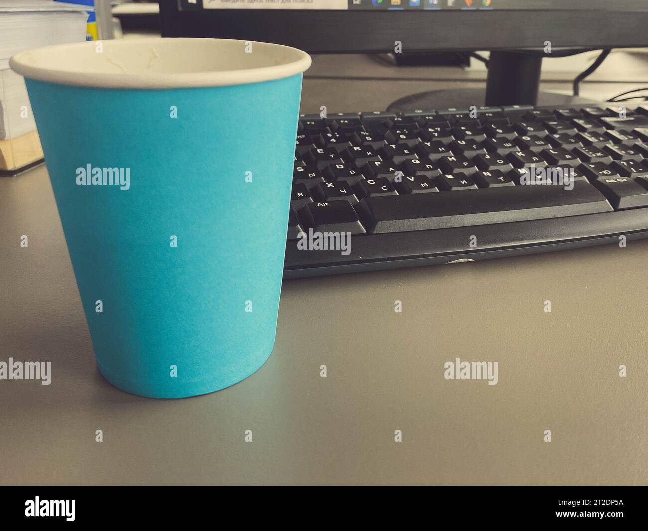 Cardboard blue coffee cup from a coffee shop on a desktop with a ...