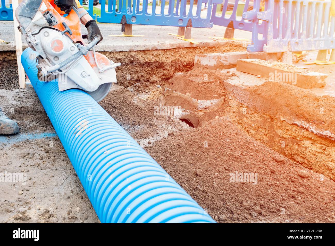 Builders cutting blue plastic water duct with petrol saw Stock Photo ...