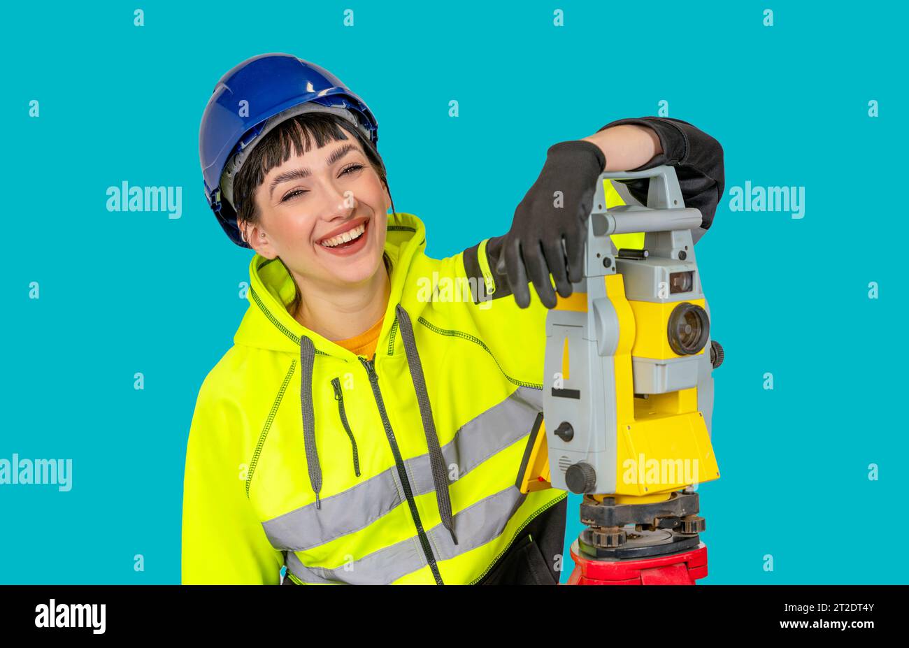 Smiling Woman in hard hat and protective clothes land surveyor working ...