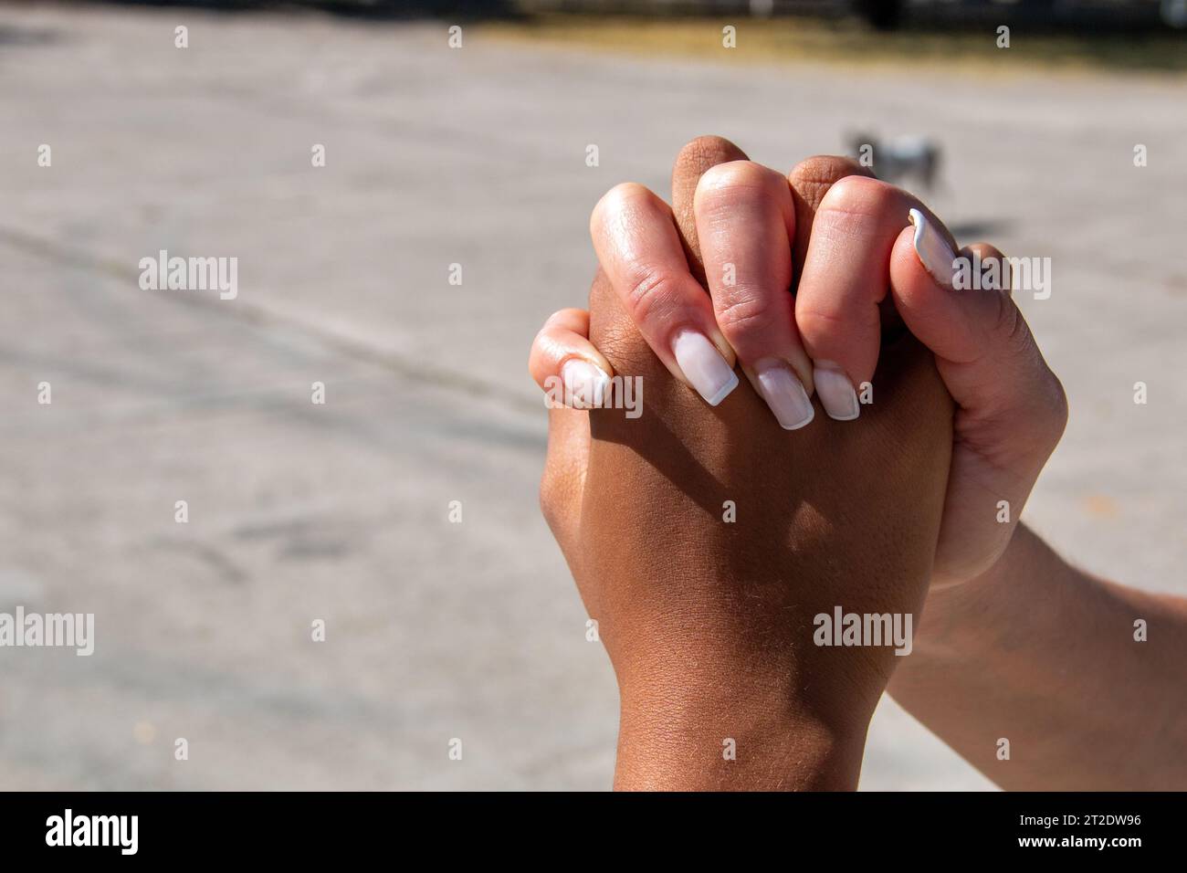 Hands of different ethnicities, African and European, together hugging ...