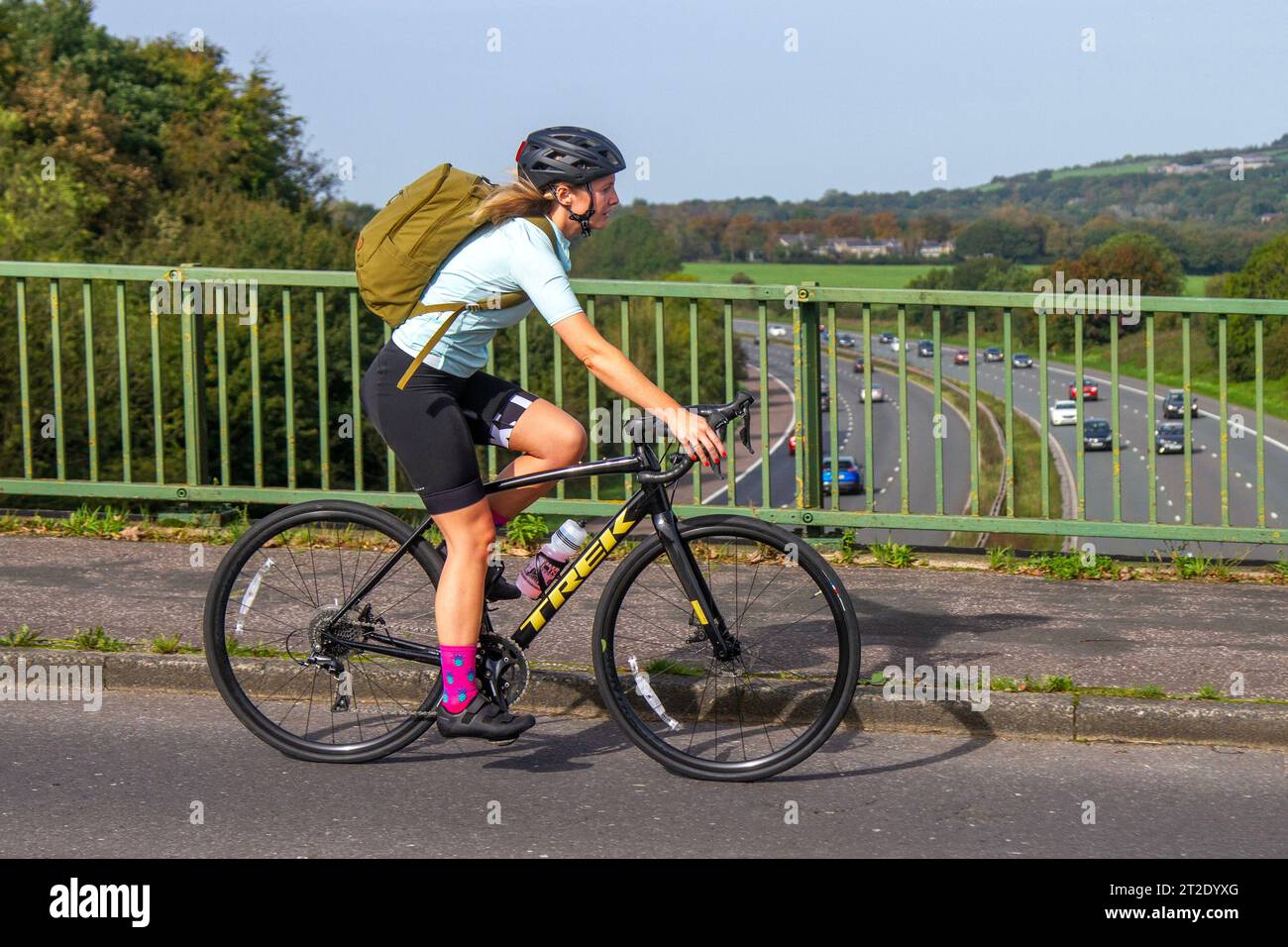 Female cyclist riding Trek sports road bike, moving road race bikes ...