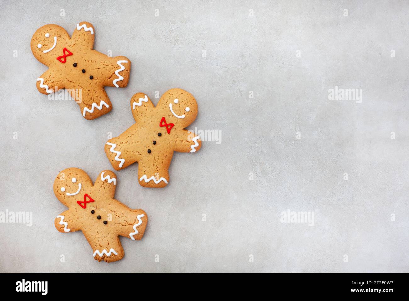 Three gingerbread men on mottled grey surface Stock Photo - Alamy