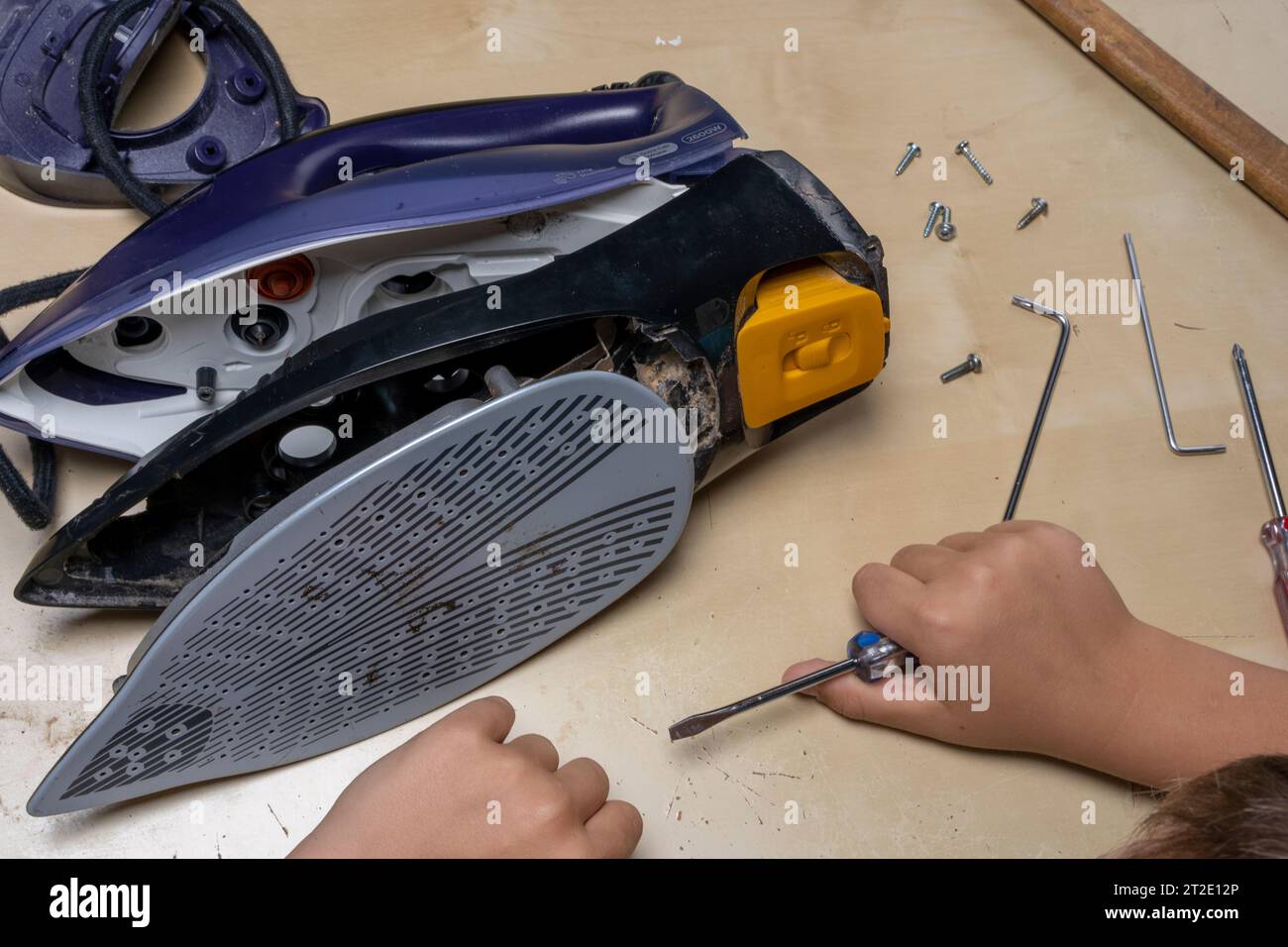 Disassembled electric iron. repairman checking and fixing broken iron ...
