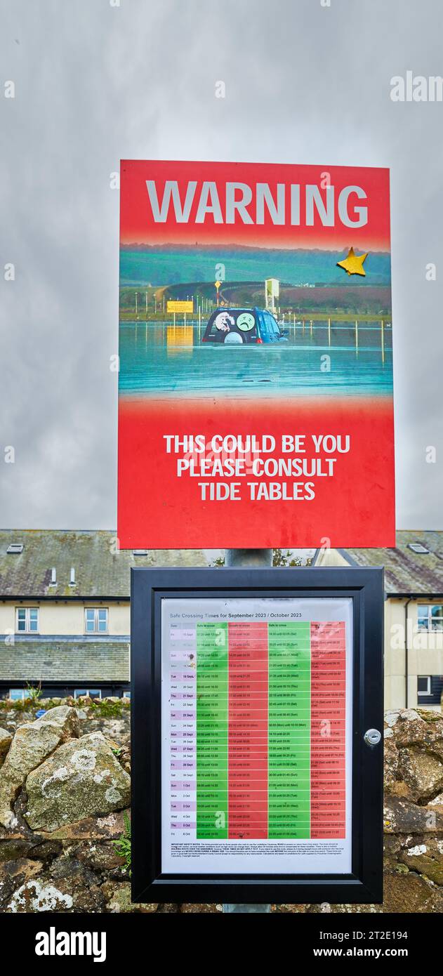 Notice board warning about crossing the causeway, when the tide is out ...