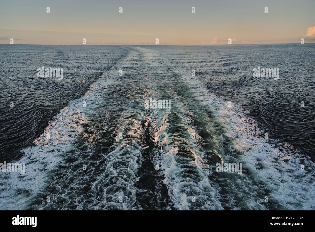 Rear view cruise ship over the empty sea with trail of waves and white ...