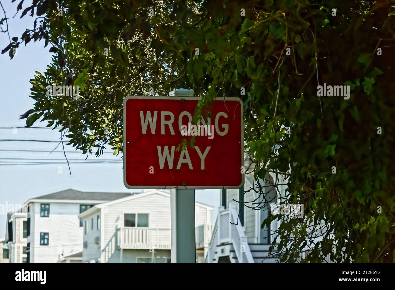 A red sign with the words 'Wrong Way' written in white lettering stands ...