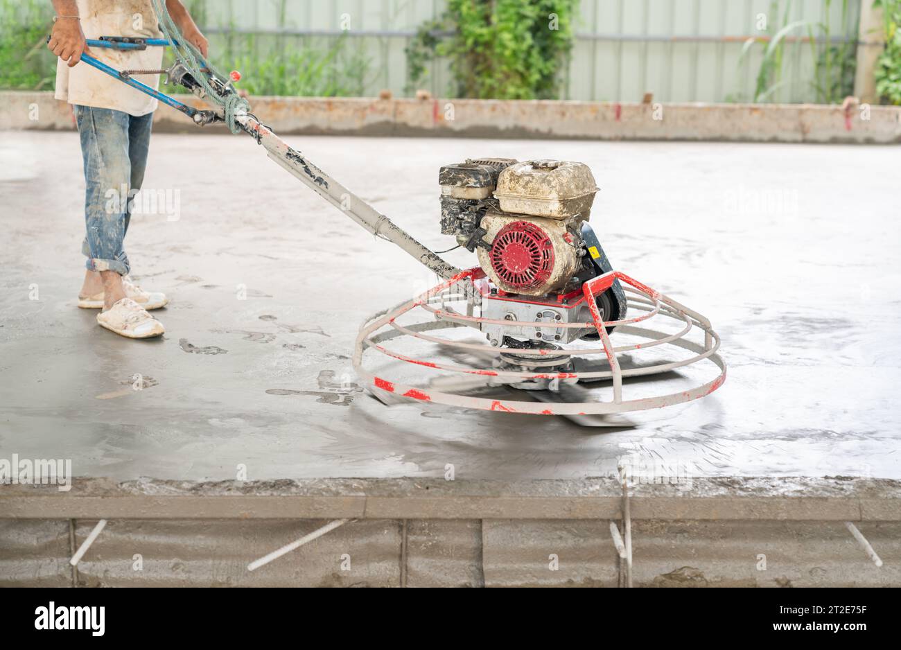 Worker use scrub floor machine to polish surface new concrete floor in ...