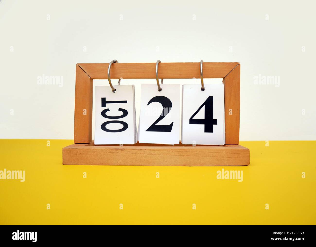 Wooden block with engraved sentence October 24 on a yellow background ...