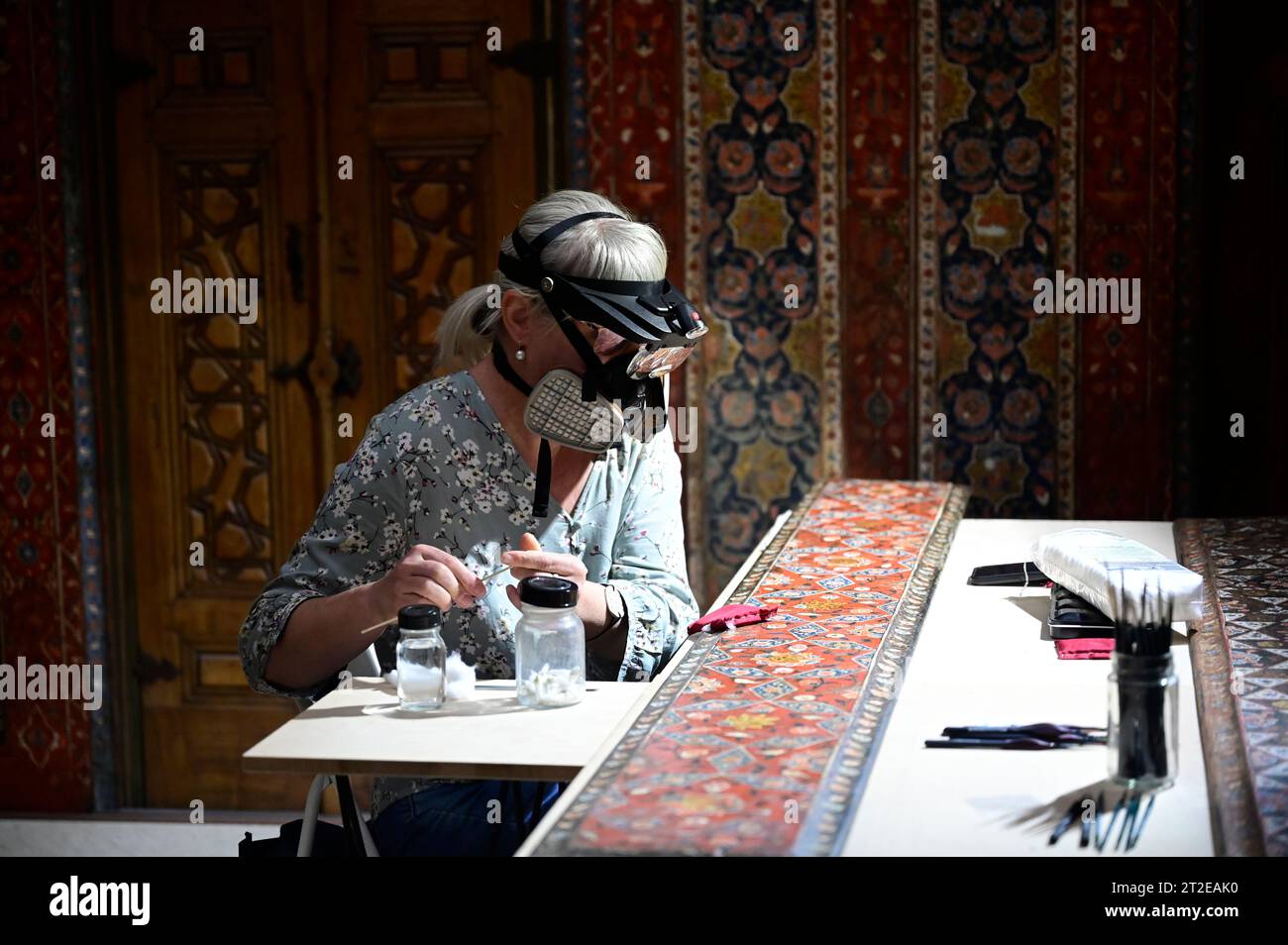 Im Bild: Eine Restauratorin arbeitet an einer historischen Vertäfelung ...