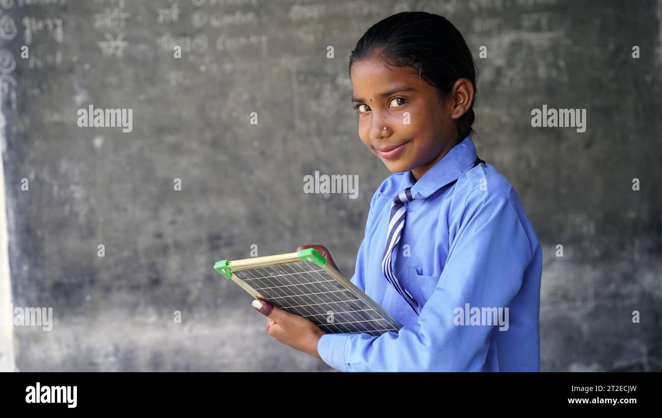 Portrait of happy cute little indian girl in school uniform holding ...