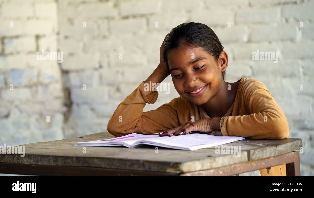 Portrait of happy indian school child sitting at desk in classroom ...