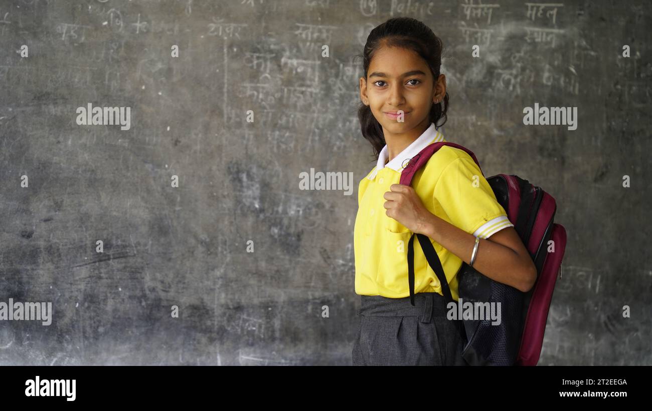 Smiling Indian Rural school girl with backpack looking at camera ...