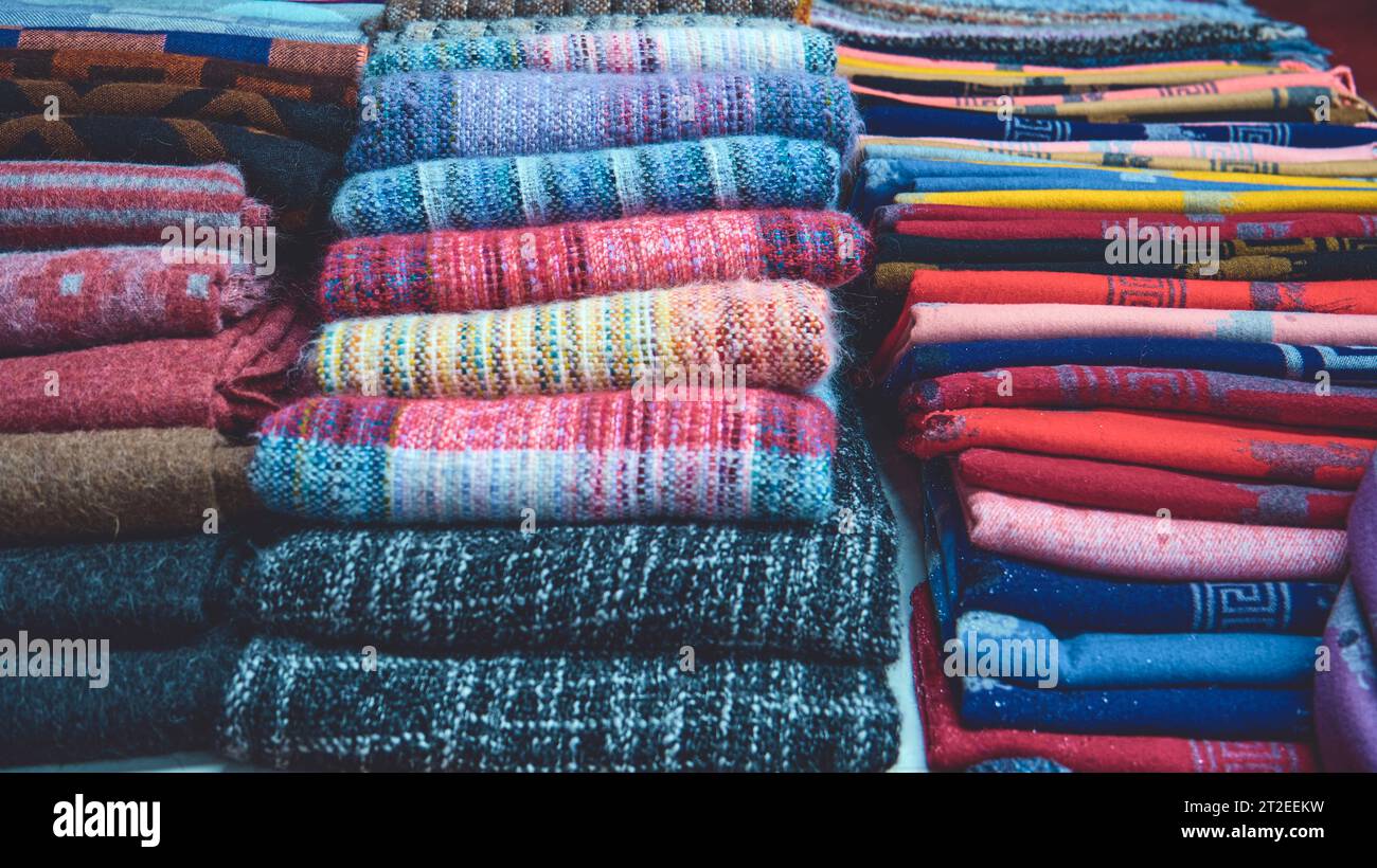 Stacked Peruvian ponchos at a street market. Natural alpaca wool in ...