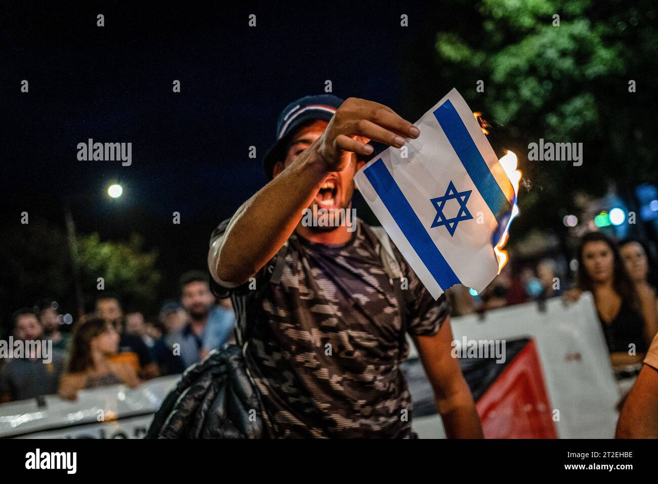 A protester burns an Israel flag during a demonstration in support of ...