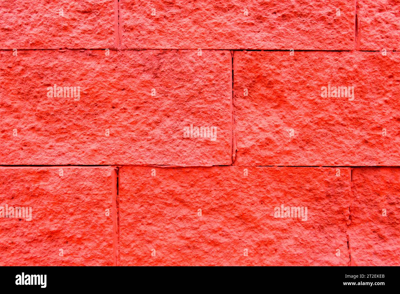 Texture of bright red large large rectangular convex stone bricks. The ...